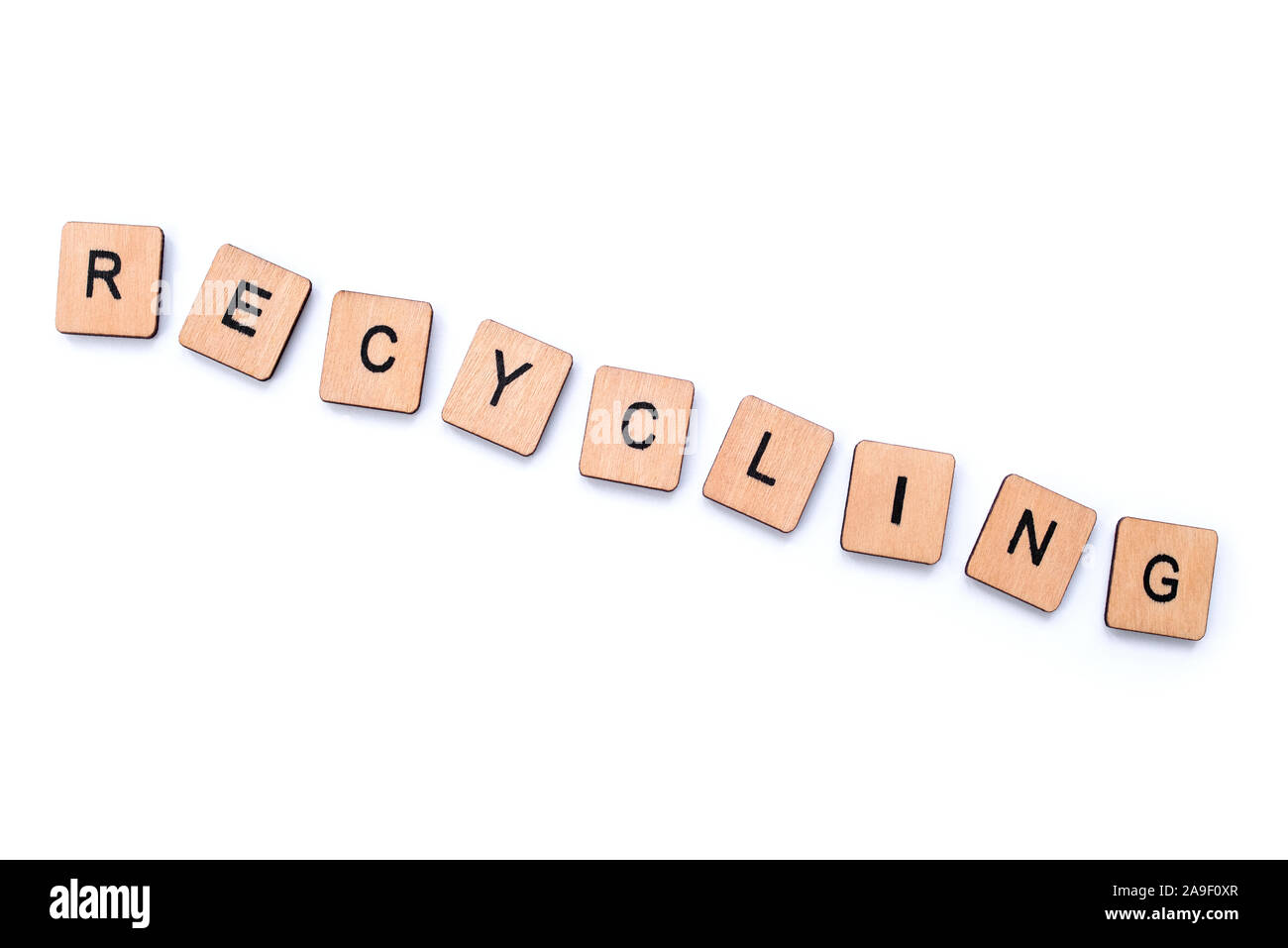 The word RECYCLING, spelt with wooden letter tiles over a white ...
