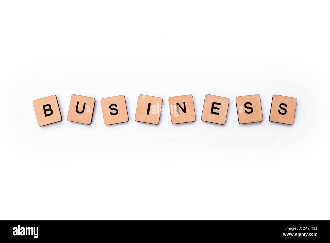 The word BUSINESS, spelt with wooden letter tiles over a white ...