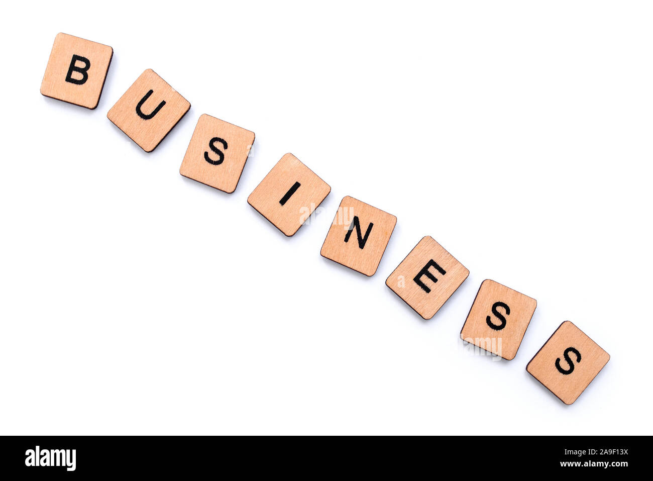 The word BUSINESS, spelt with wooden letter tiles over a white ...