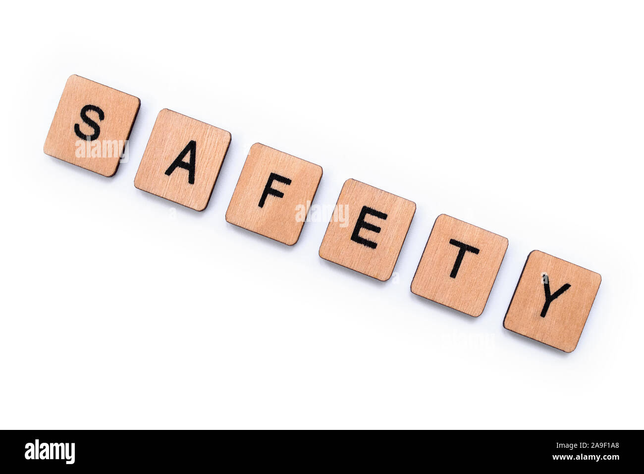 The word SAFETY, spelt with wooden letter tiles over a white background ...