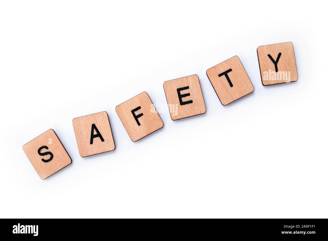The word SAFETY, spelt with wooden letter tiles over a white background ...