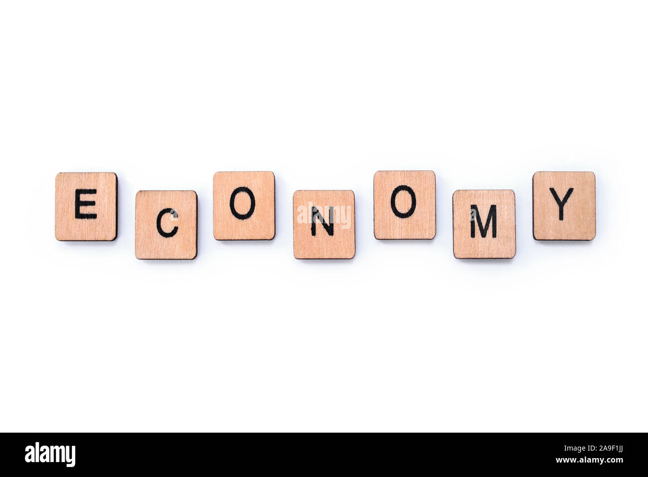 The word ECONOMY, spelt with wooden letter tiles over a white ...