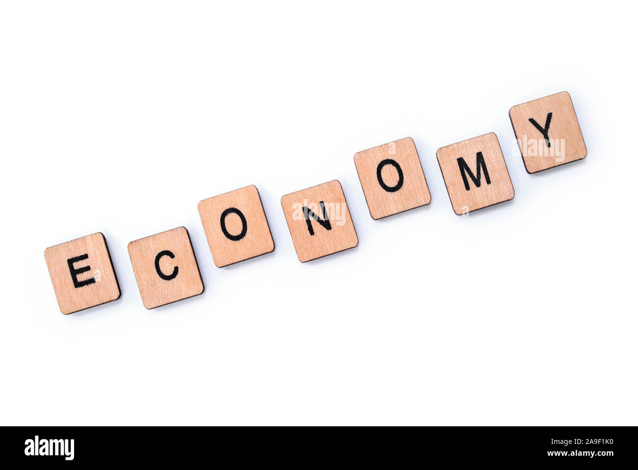 The word ECONOMY, spelt with wooden letter tiles over a white ...