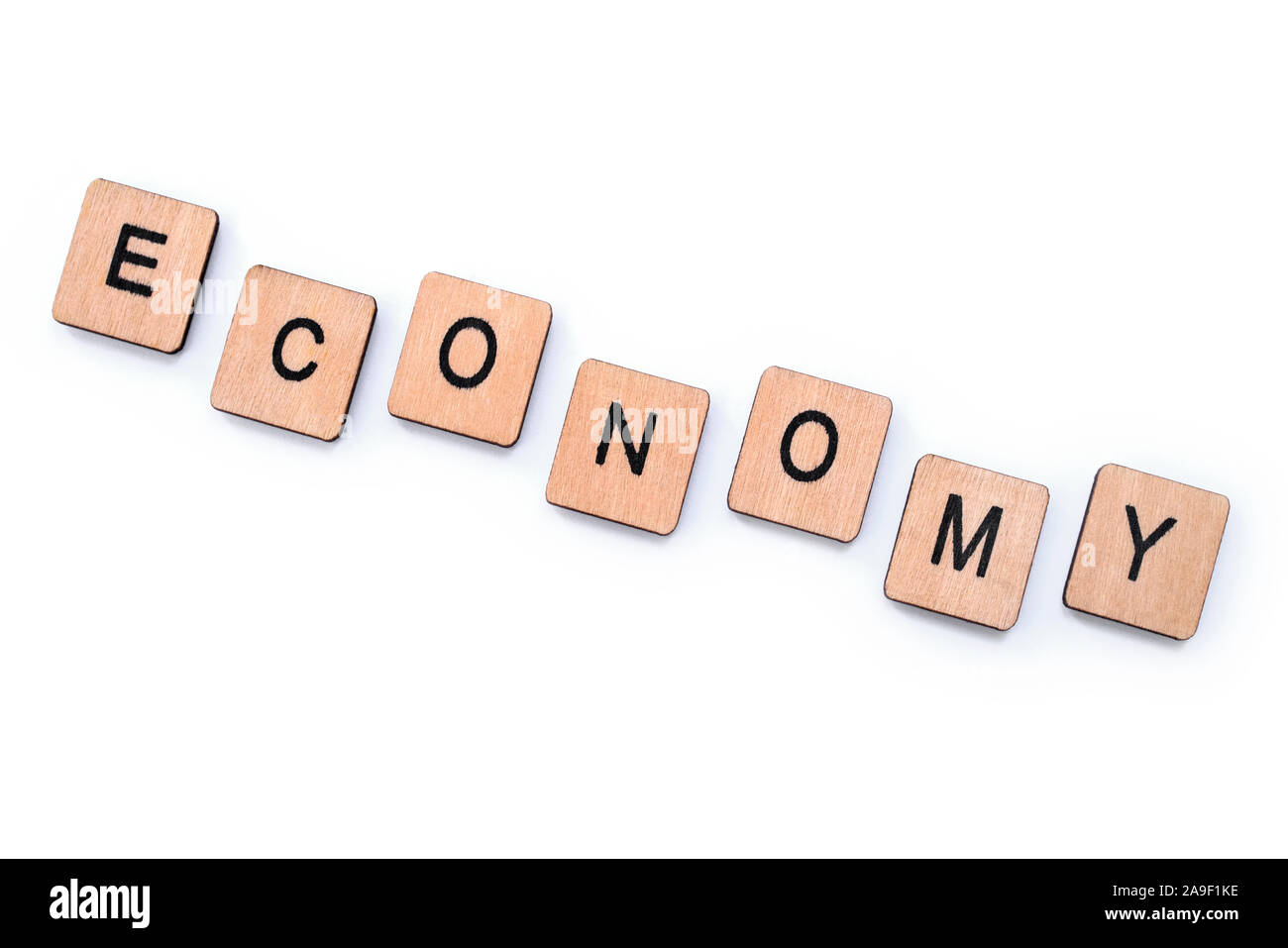 The word ECONOMY, spelt with wooden letter tiles over a white ...