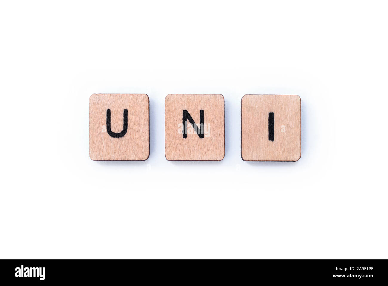 The word UNI, spelt with wooden letter tiles on a white background ...