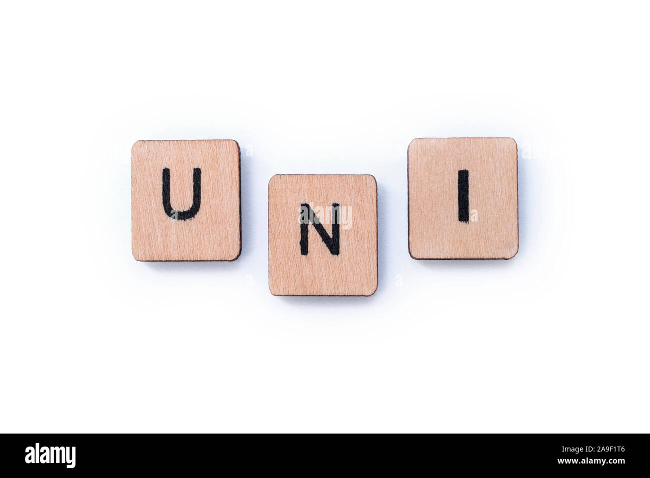The word UNI, spelt with wooden letter tiles on a white background ...