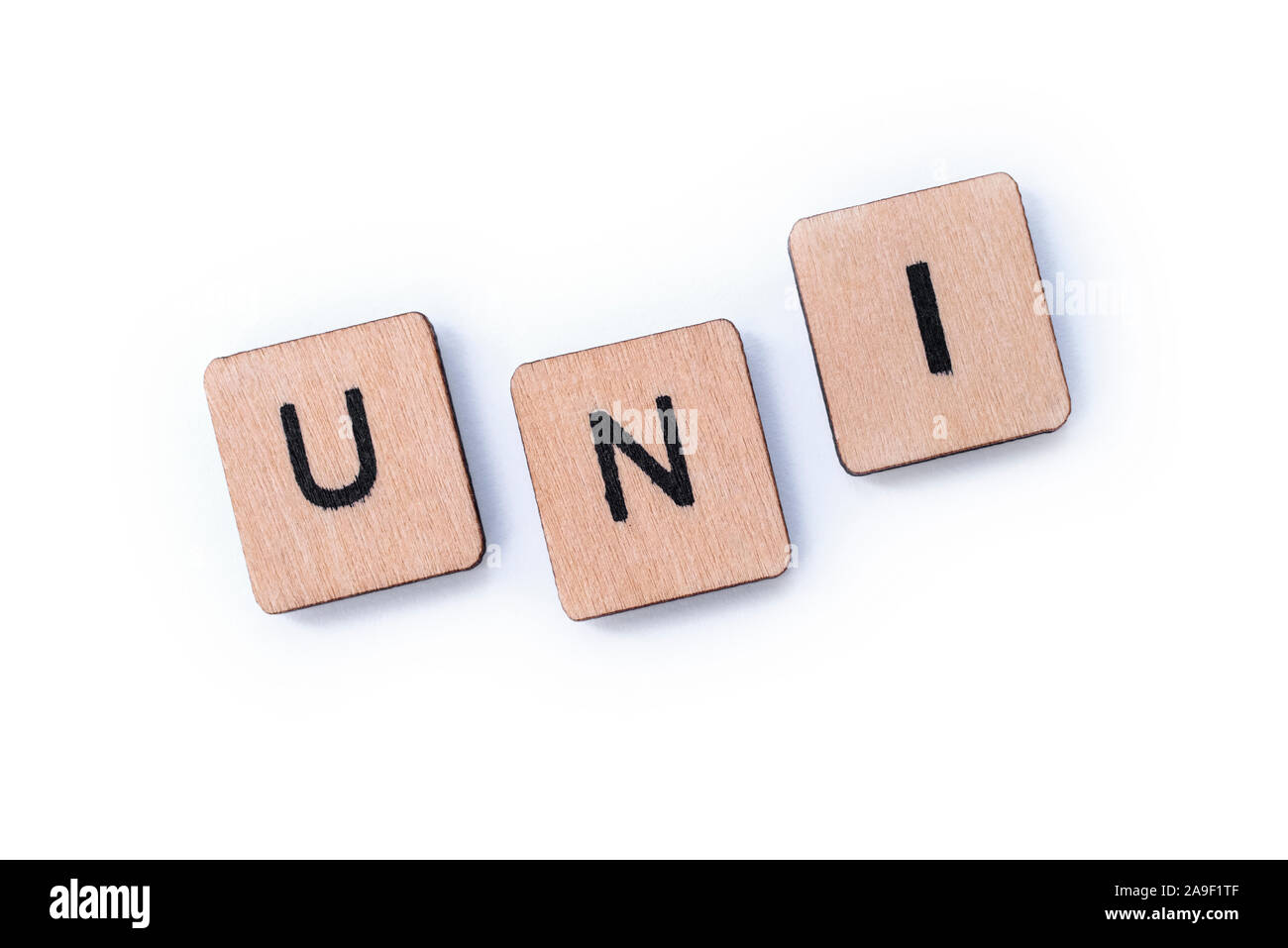 The word UNI, spelt with wooden letter tiles on a white background ...