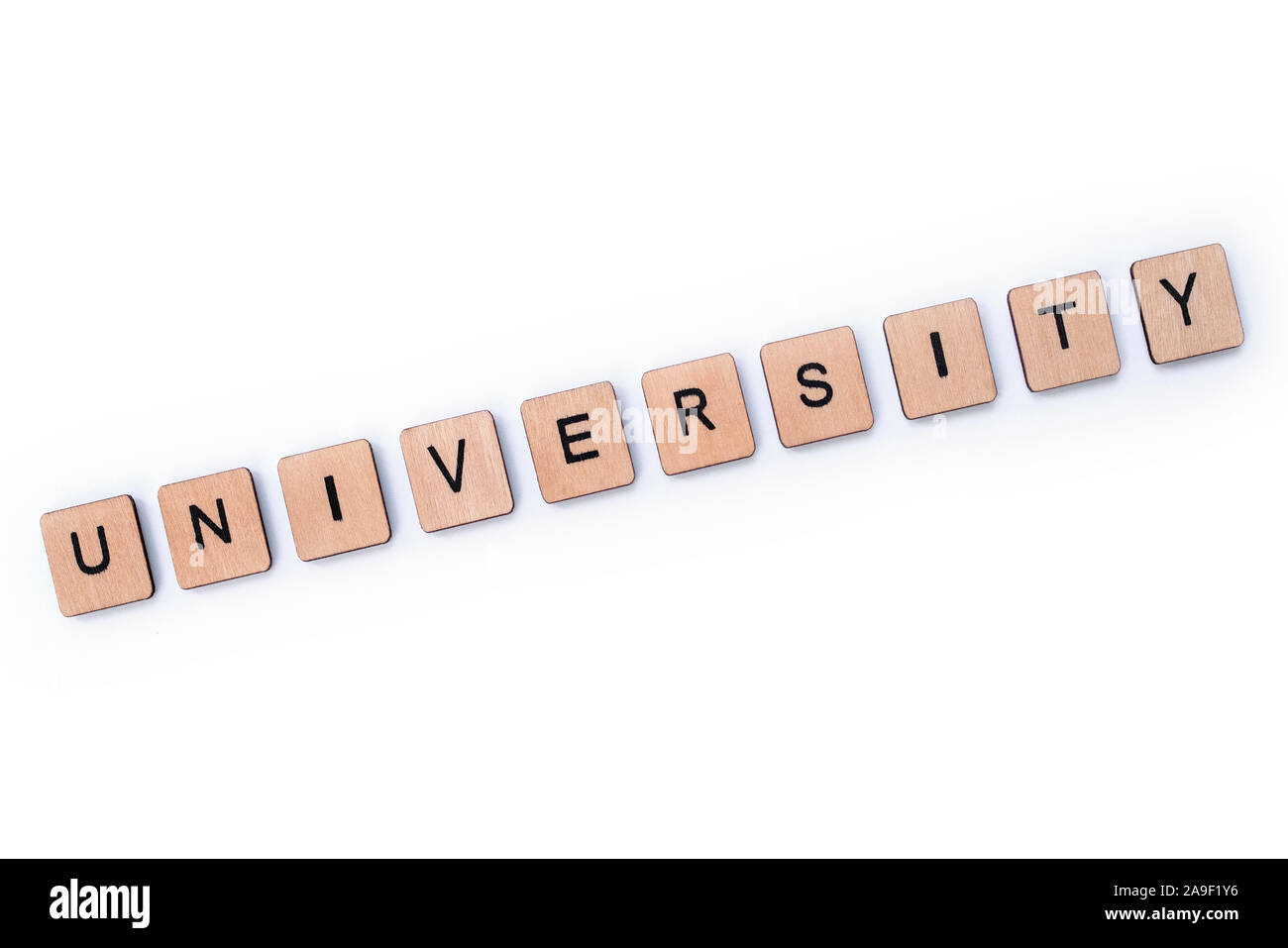 The word UNIVERSITY, spelt with wooden letter tiles on a white ...
