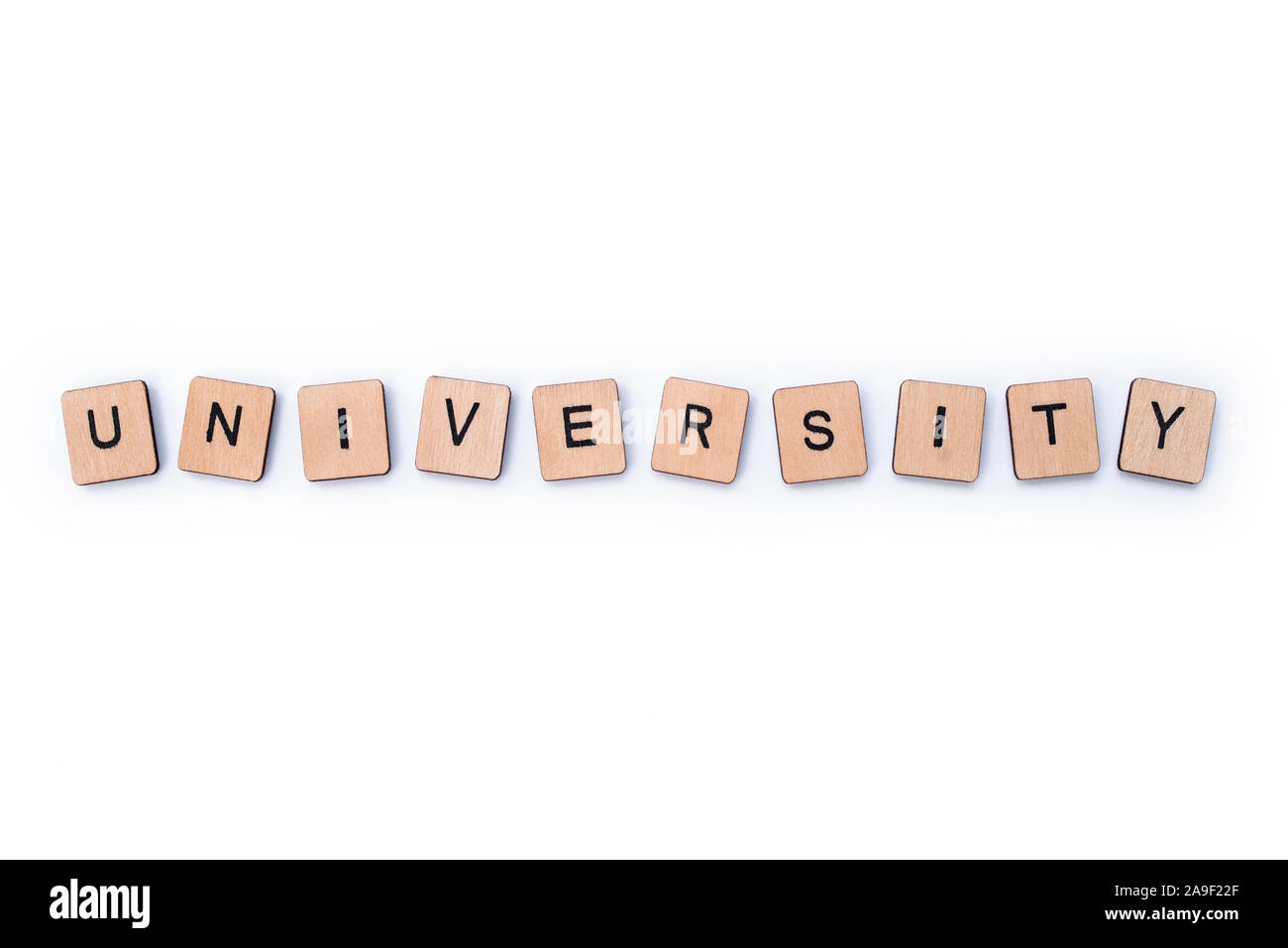 The word UNIVERSITY, spelt with wooden letter tiles on a white ...