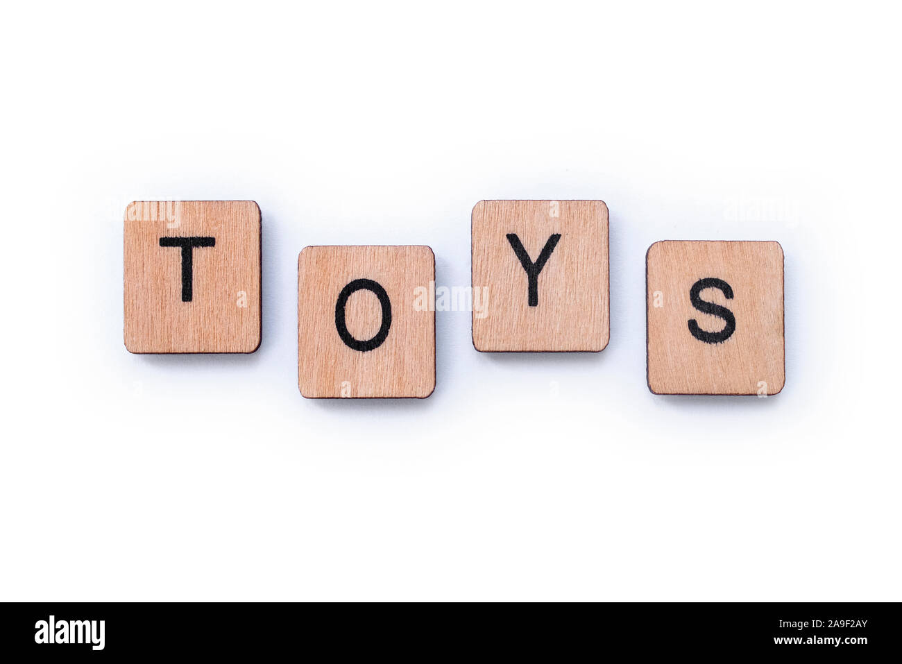 The word TOYS, spelt with wooden letter tiles over a white background ...