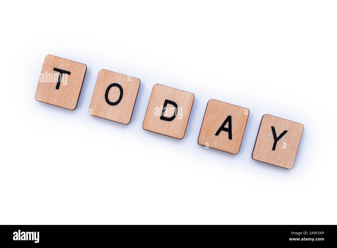 The word TODAY, spelt with wooden letter tiles over a white background ...