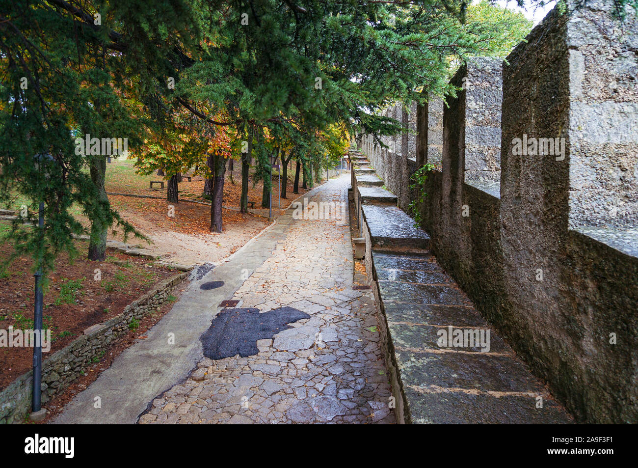 Alley walkway, path in autumn park with colorful trees and stone wall ...