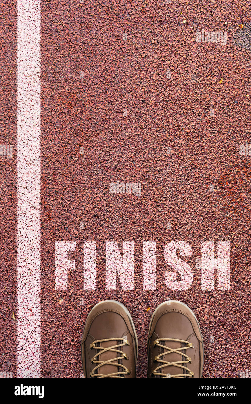 Word Finish written on rubber sports track background. Foot and legs ...