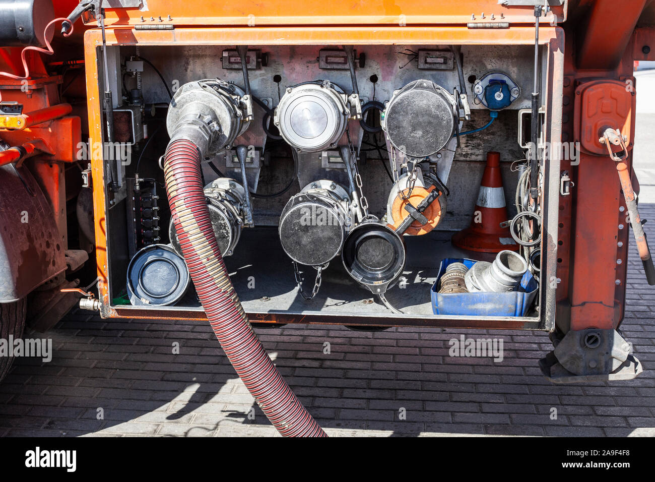 A fuel truck pumps gasoline through a hose to a gas station. A gas ...