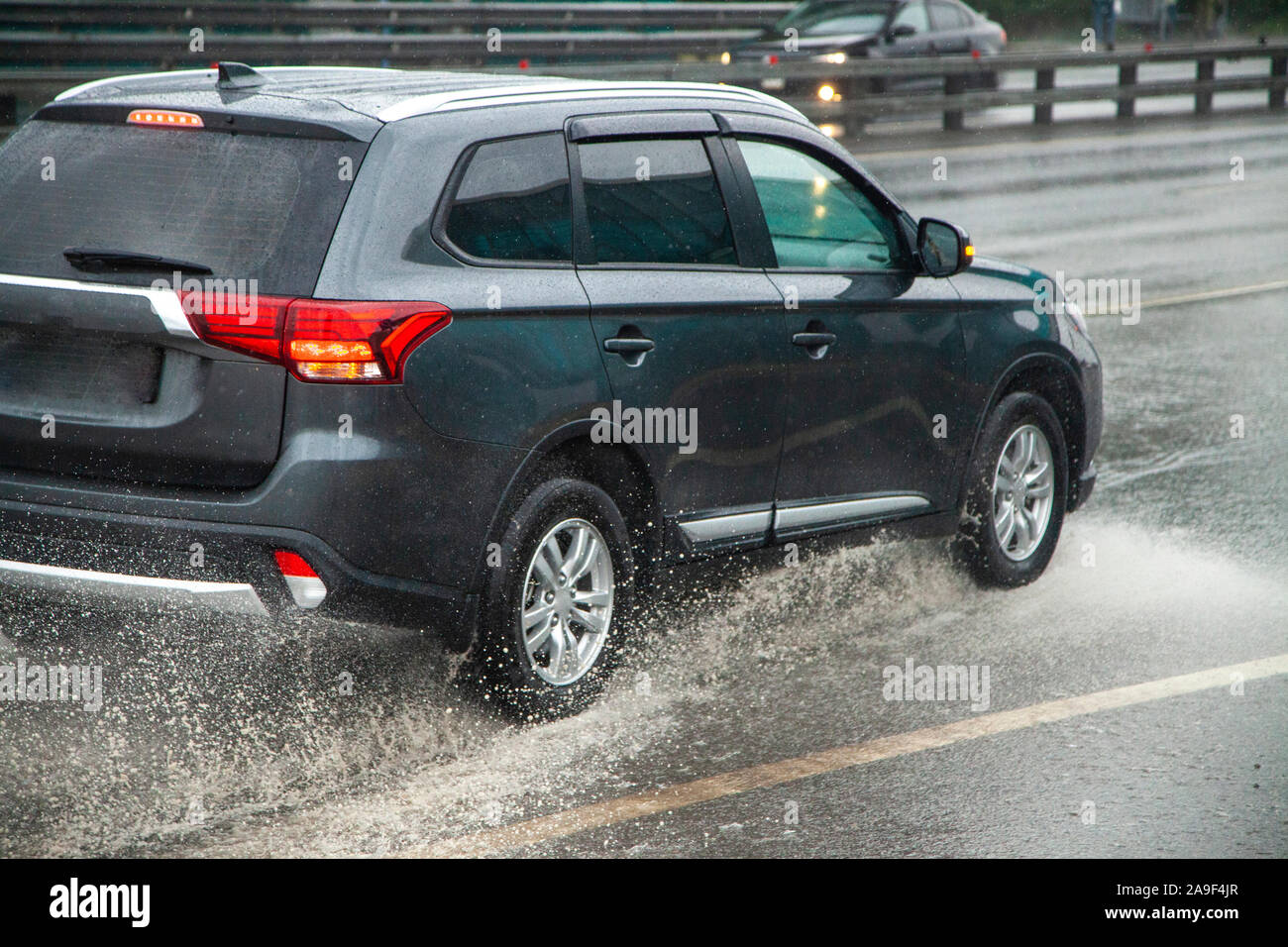 SUV rides in the rain. Car tires in bad weather. Fast ride on the track ...