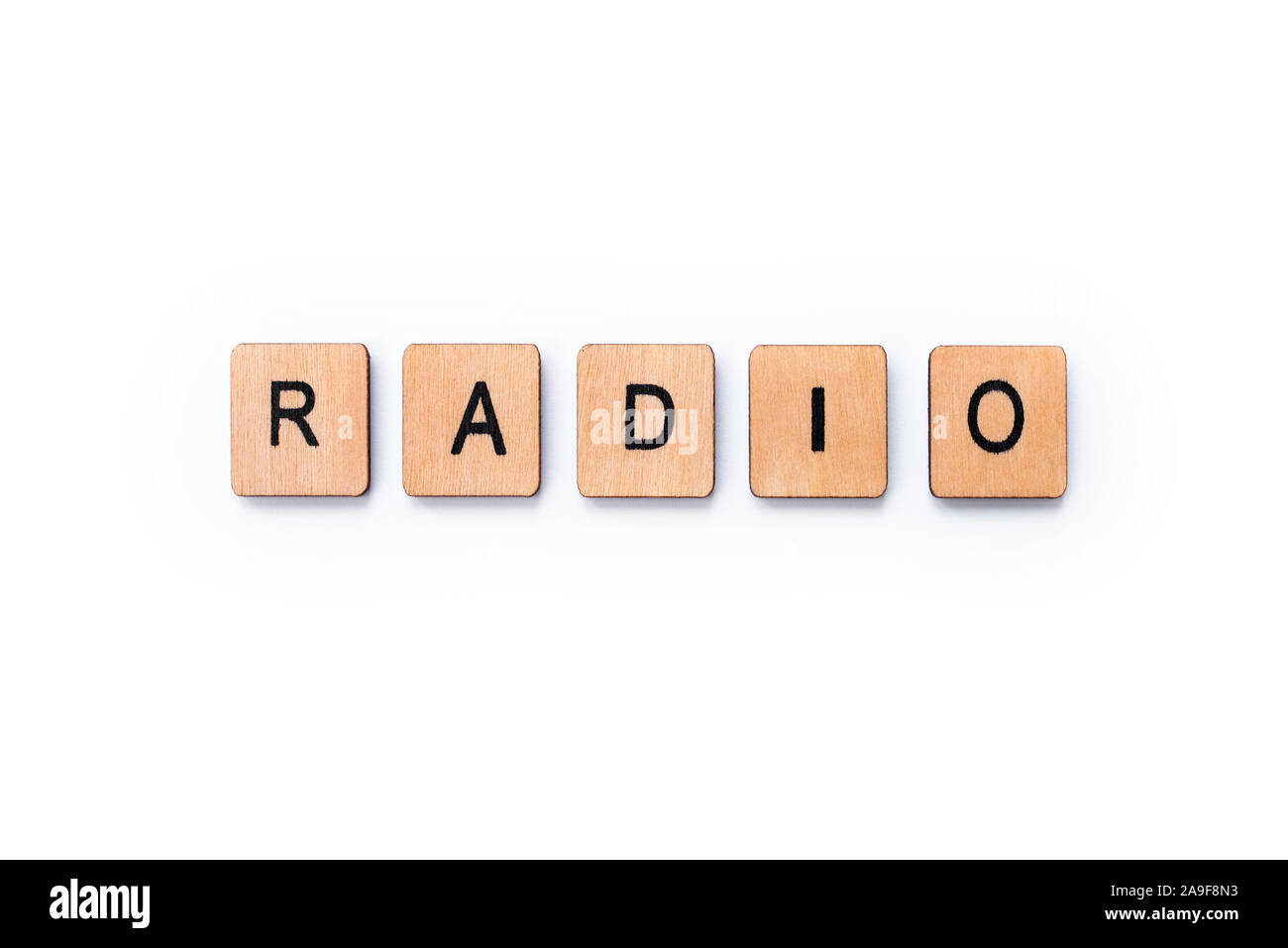 The word RADIO, spelt with wooden letter tiles over a white background ...