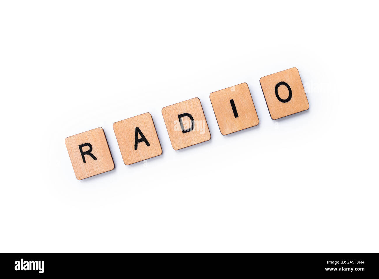 The word RADIO, spelt with wooden letter tiles over a white background ...