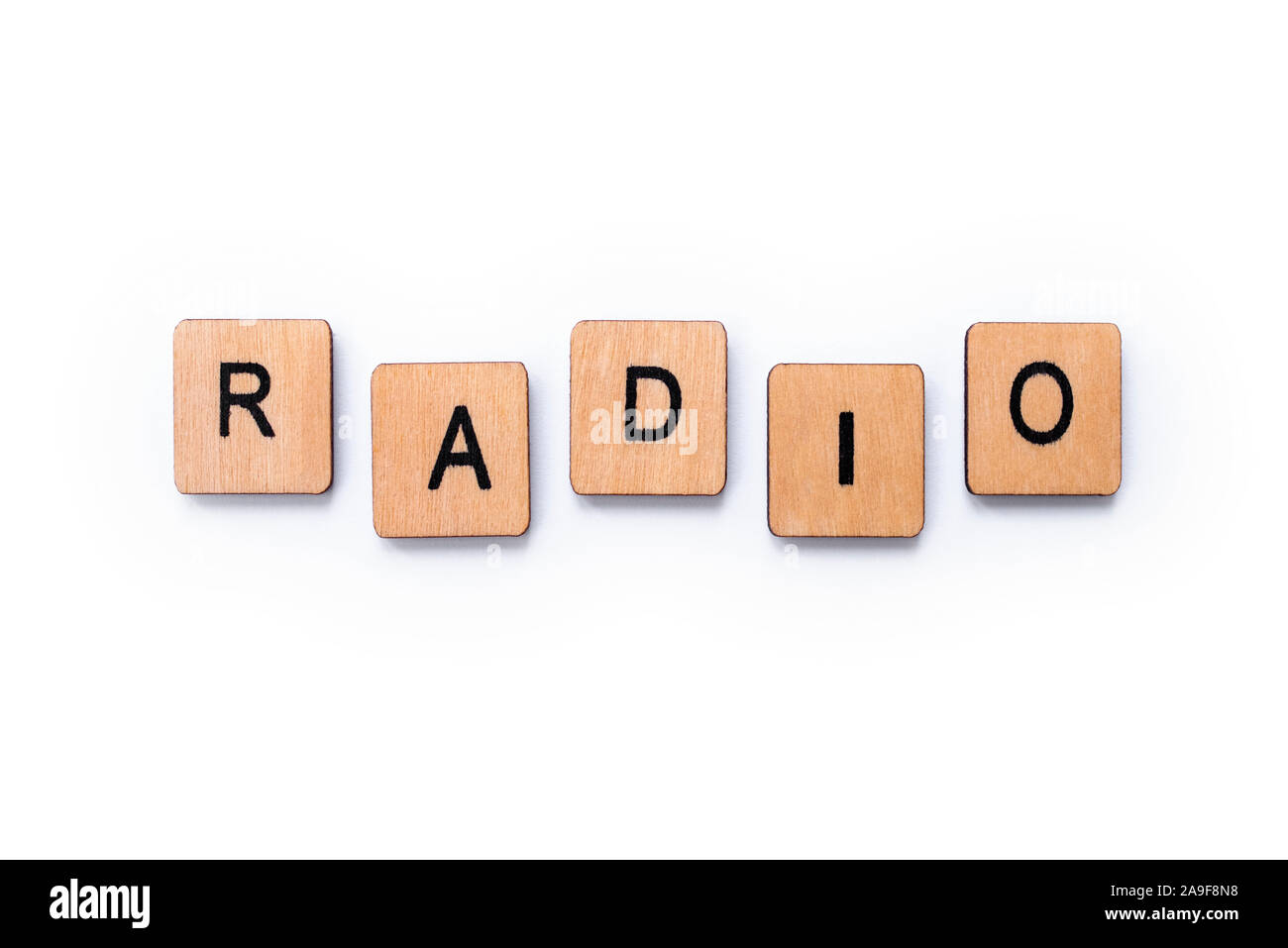 The word RADIO, spelt with wooden letter tiles over a white background ...