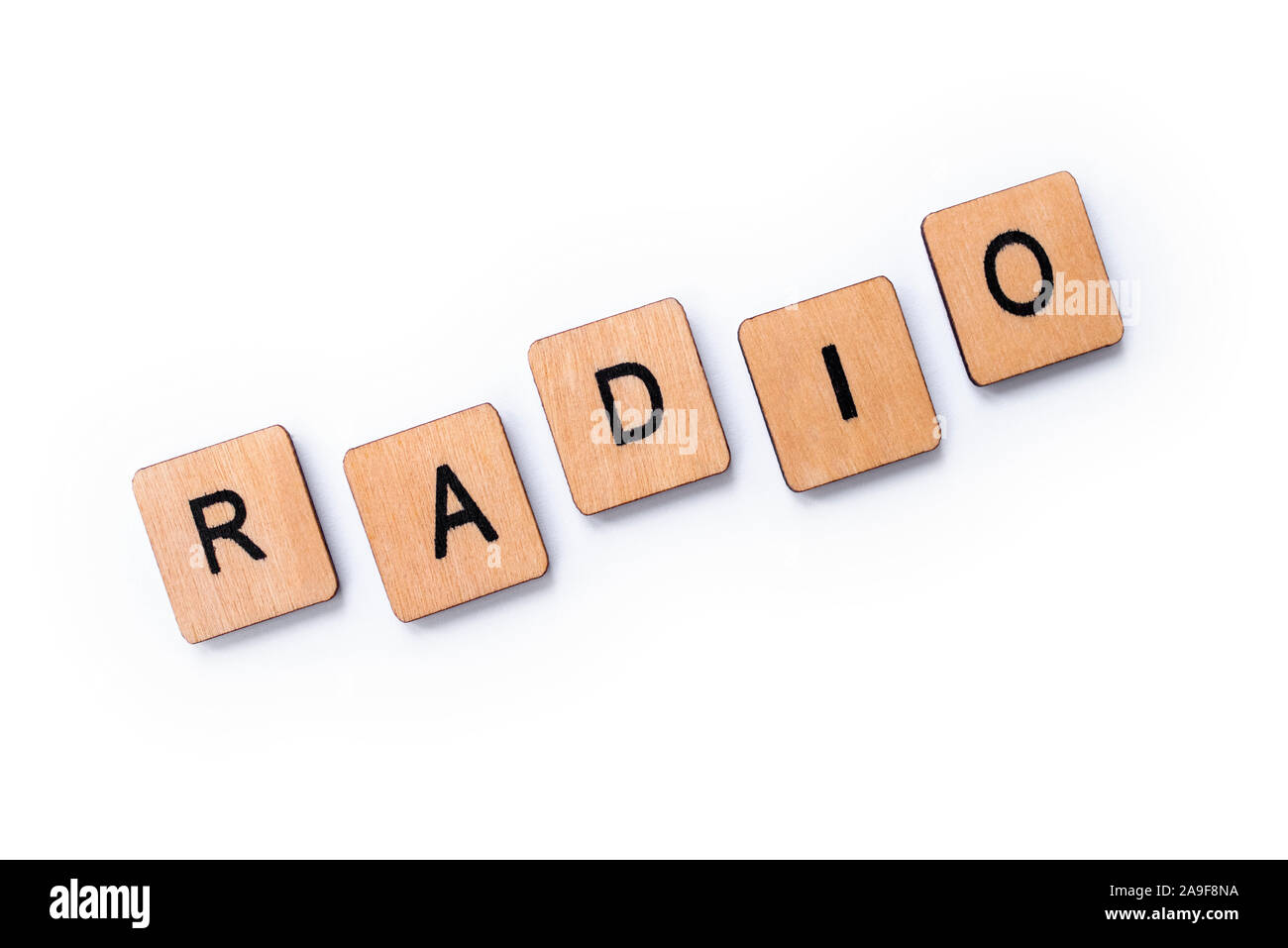 The word RADIO, spelt with wooden letter tiles over a white background ...