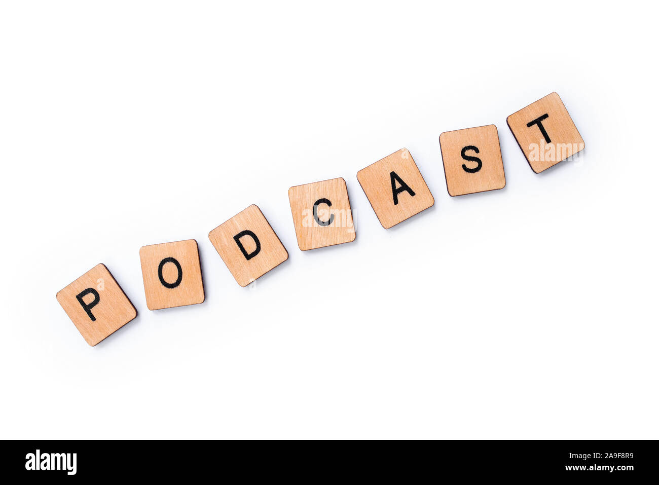 The word PODCAST, spelt with wooden letter tiles over a white ...