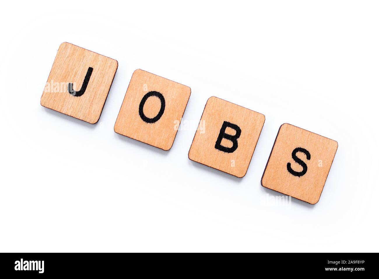 The word JOBS, spelt with wooden letter tiles over a white background ...