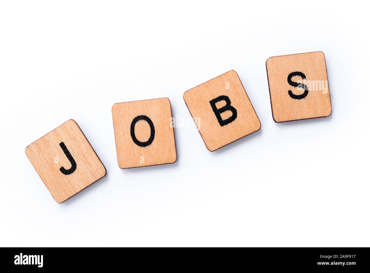 The word JOBS, spelt with wooden letter tiles over a white background ...