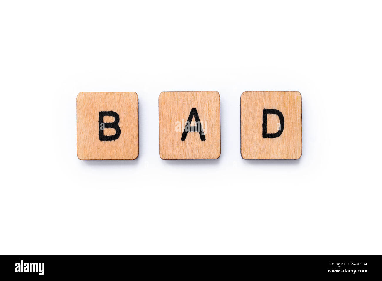 The word BAD, spelt with wooden letter tiles over a white background ...