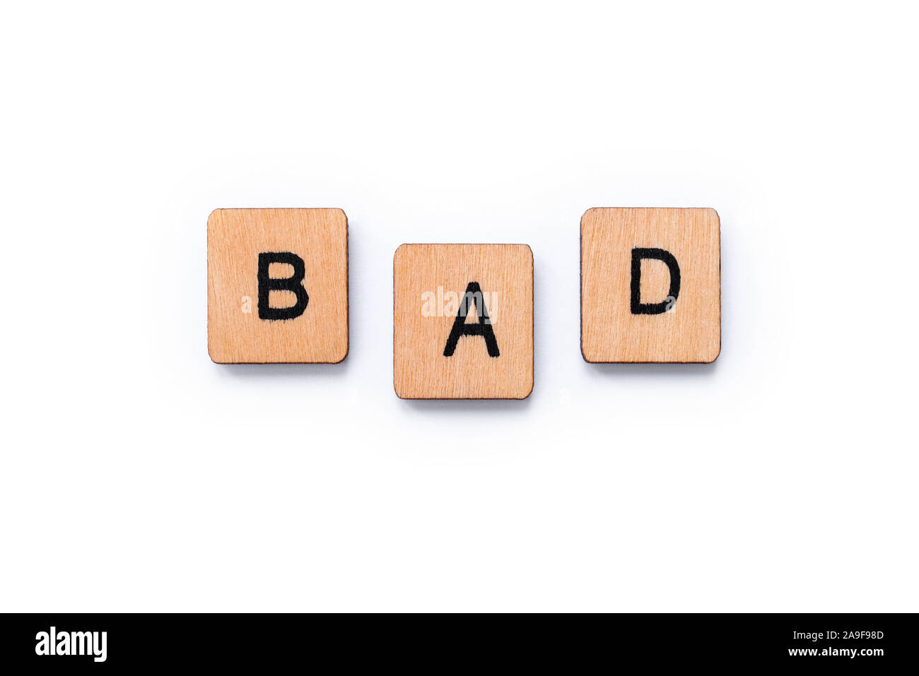 The word BAD, spelt with wooden letter tiles over a white background ...