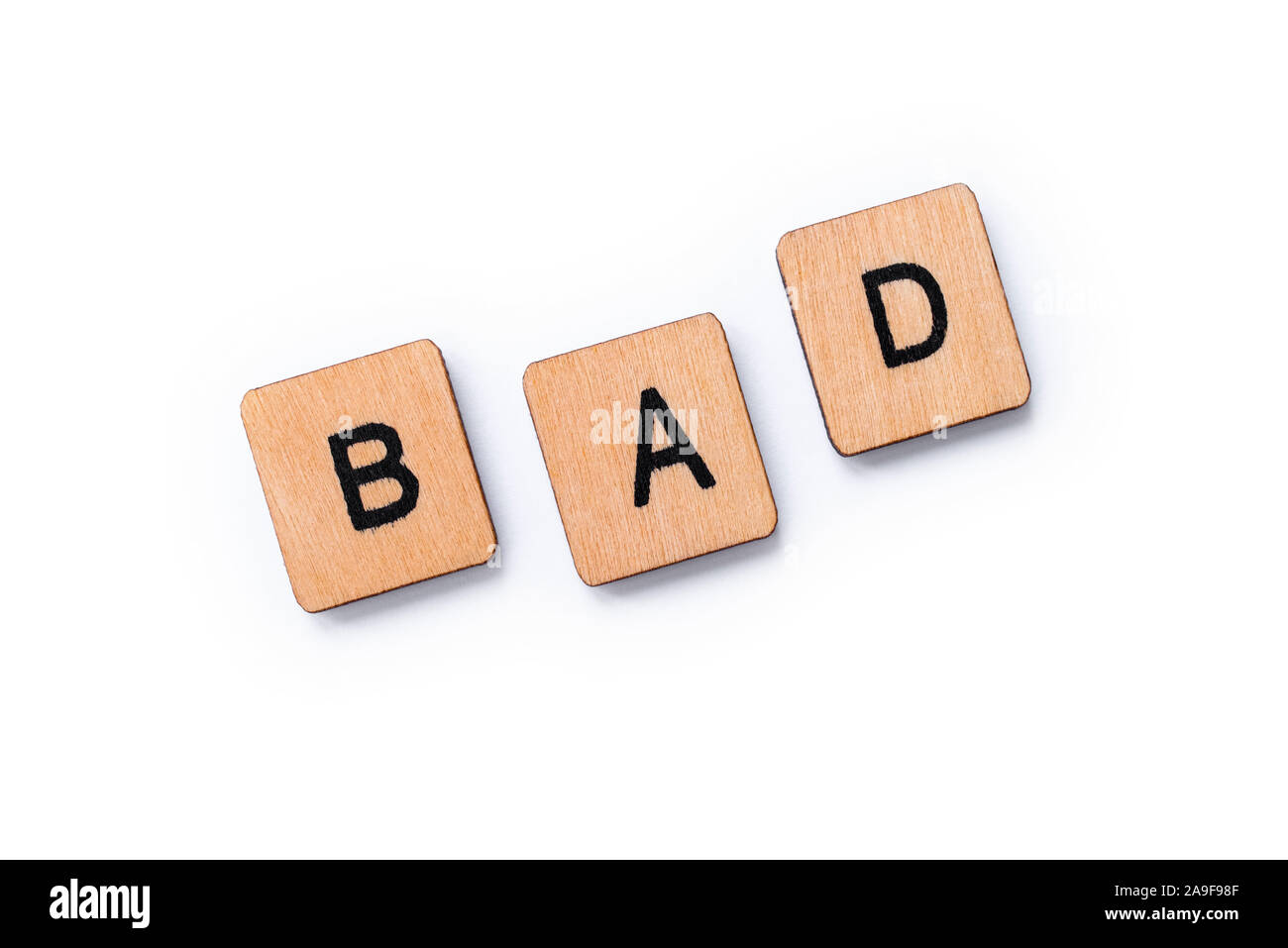 The word BAD, spelt with wooden letter tiles over a white background ...