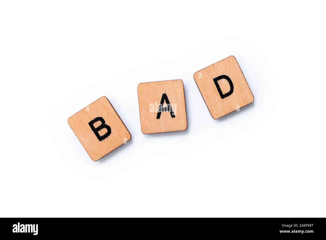The word BAD, spelt with wooden letter tiles over a white background ...