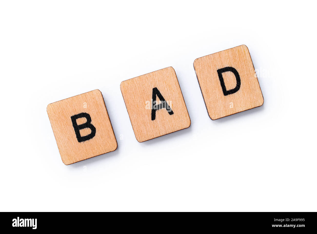 The word BAD, spelt with wooden letter tiles over a white background ...