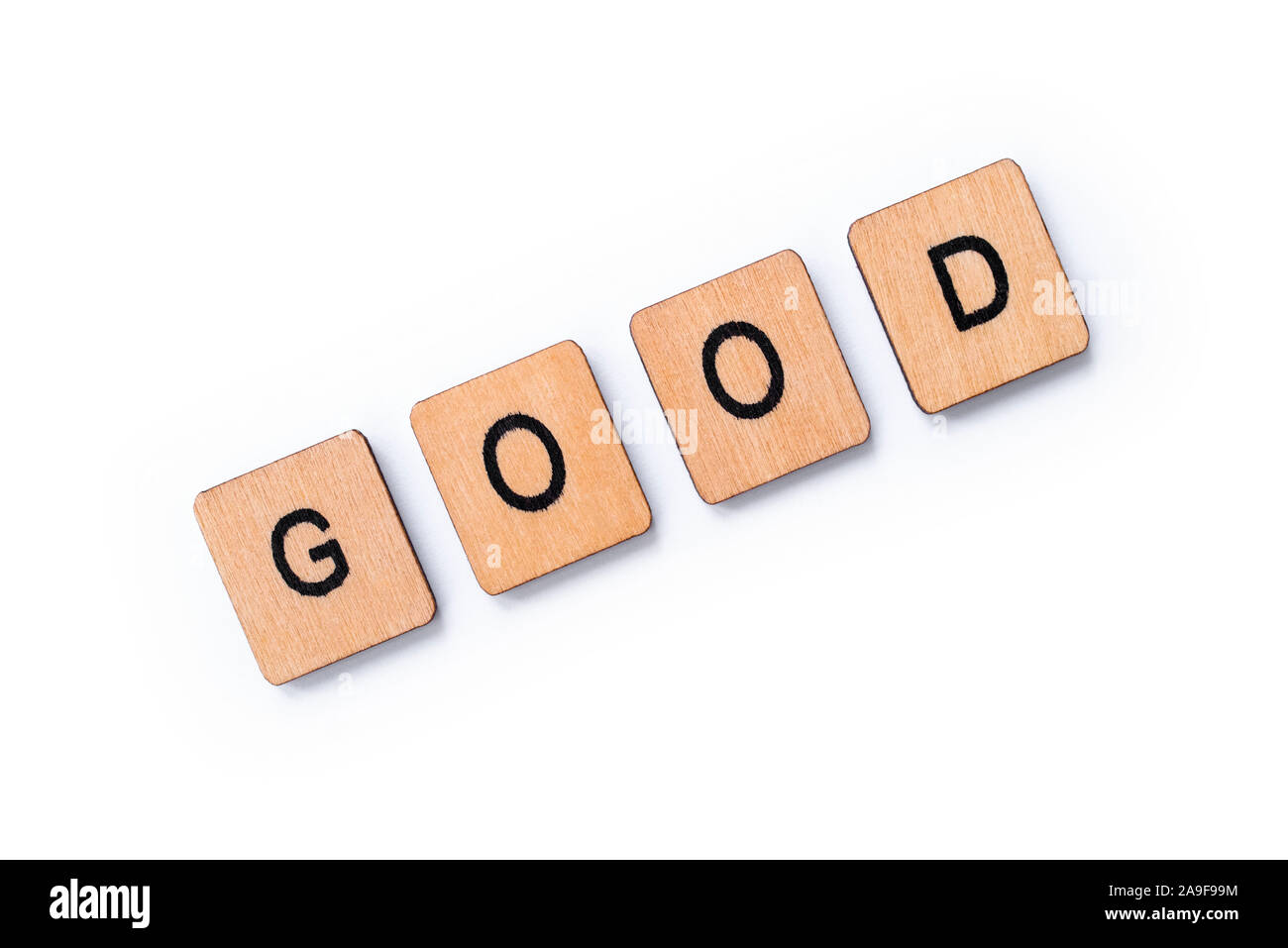 The word GOOD, spelt with wooden letter tiles over a white background ...