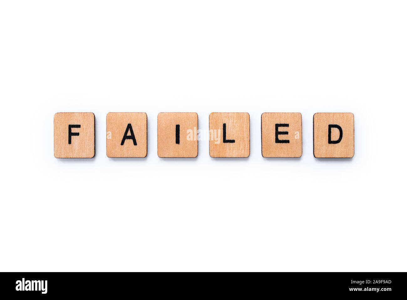 The word FAILED, spelt with wooden letter tiles over a white background ...