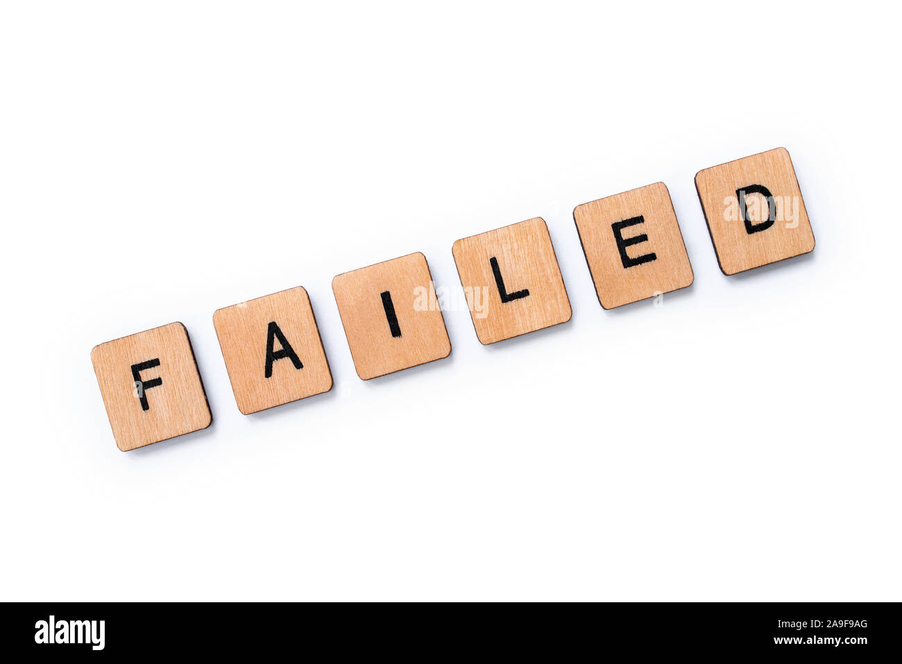 The word FAILED, spelt with wooden letter tiles over a white background ...