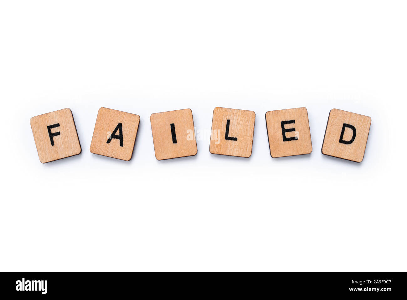 The word FAILED, spelt with wooden letter tiles over a white background ...