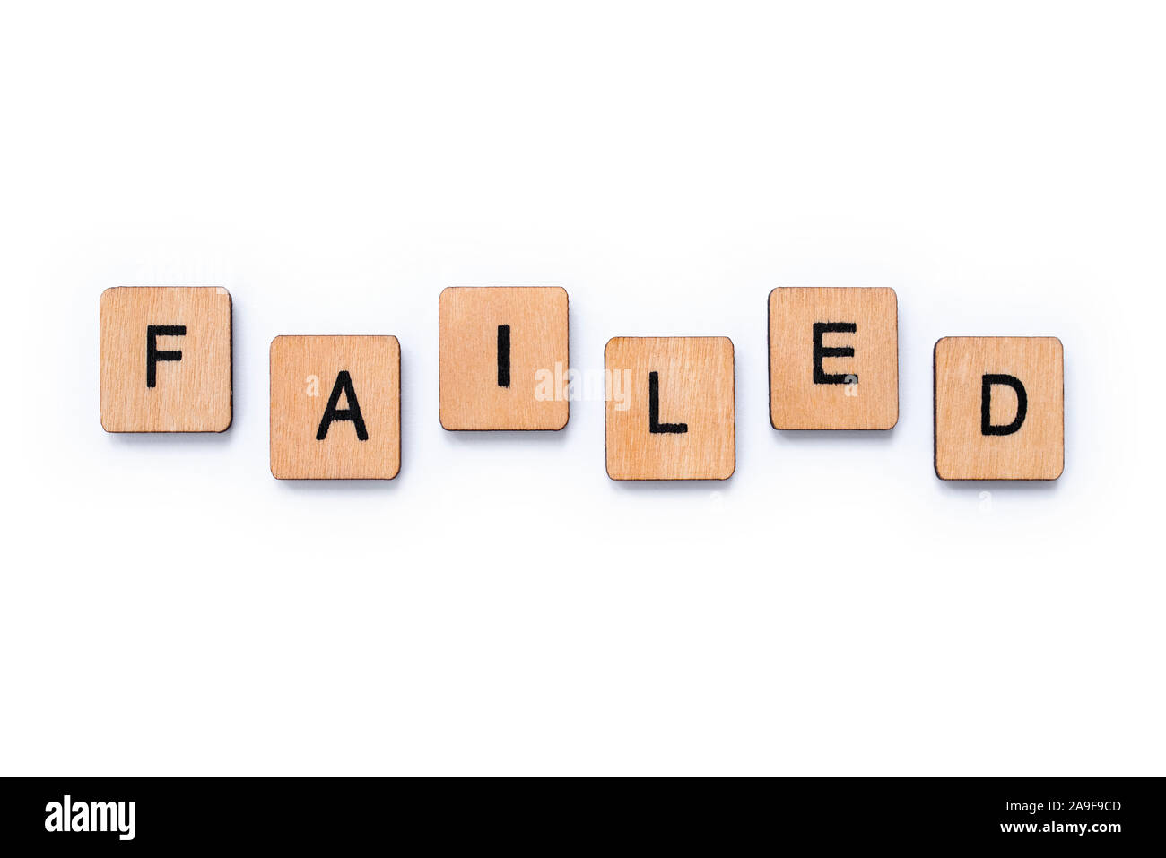 The word FAILED, spelt with wooden letter tiles over a white background ...