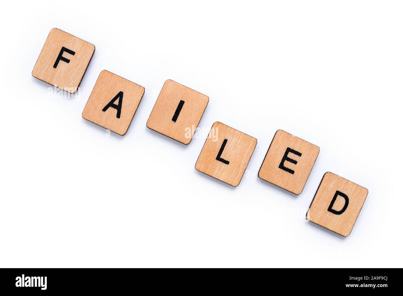 The word FAILED, spelt with wooden letter tiles over a white background ...