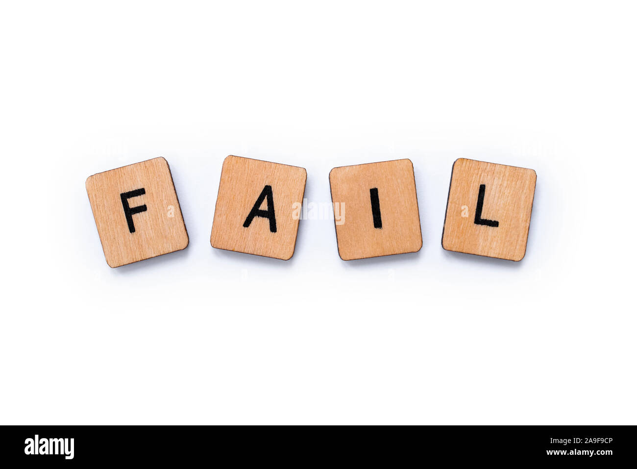 The word FAIL, spelt with wooden letter tiles over a white background ...