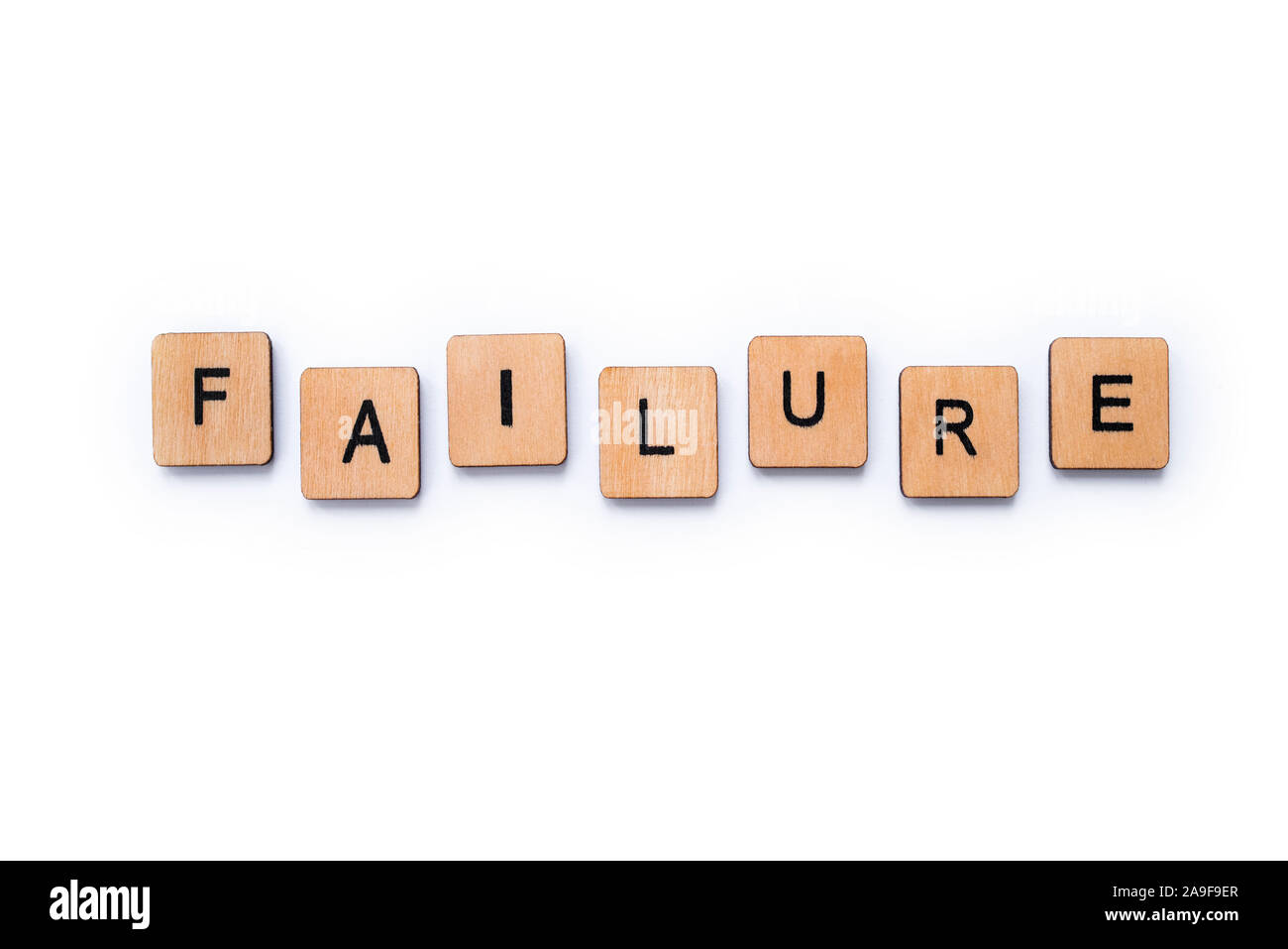 The word FAILURE, spelt with wooden letter tiles over a white ...