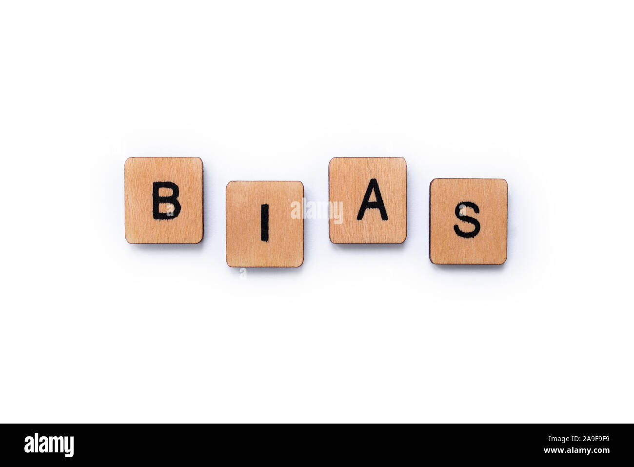 The word BIAS, spelt with wooden letter tiles over a white background ...