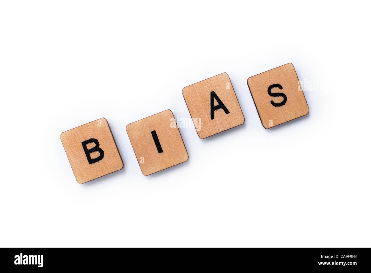 The word BIAS, spelt with wooden letter tiles over a white background ...