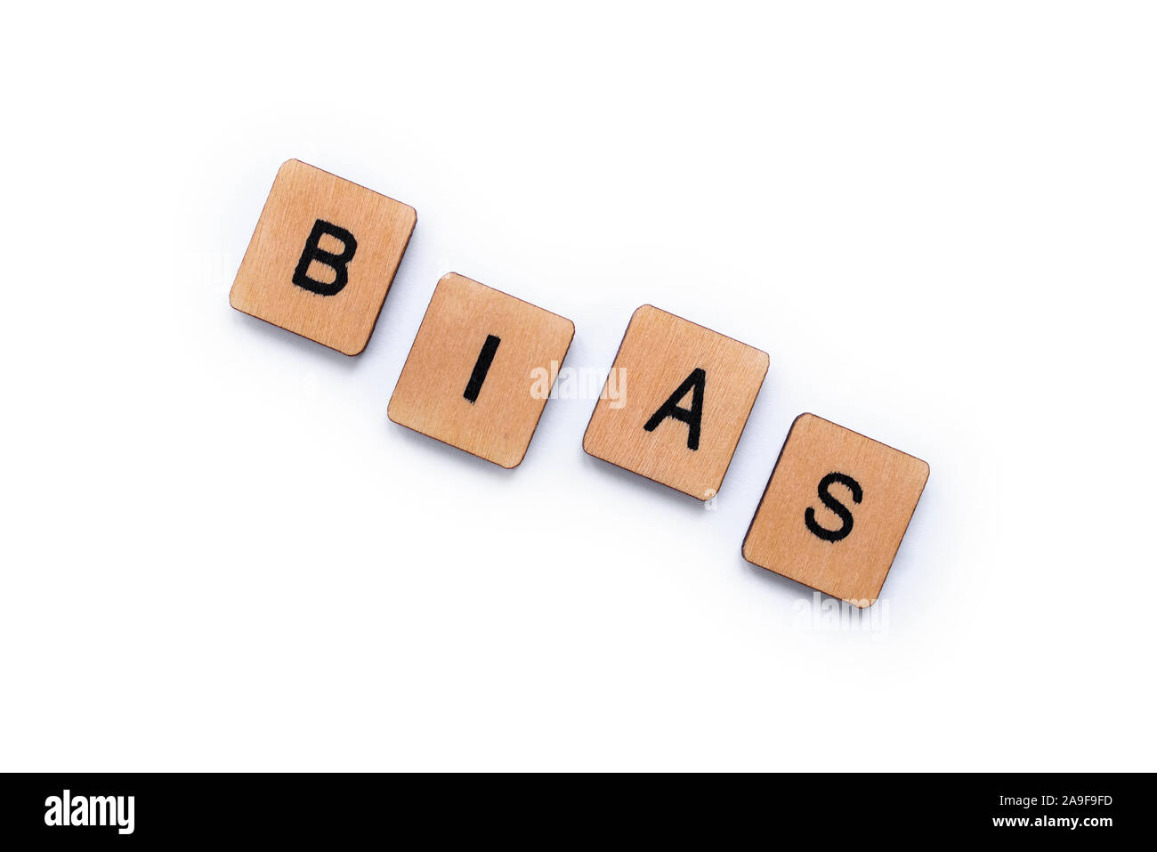 The word BIAS, spelt with wooden letter tiles over a white background ...