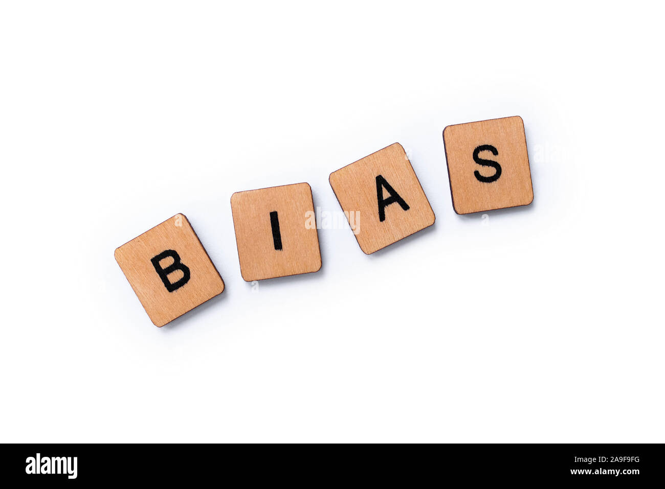The word BIAS, spelt with wooden letter tiles over a white background ...