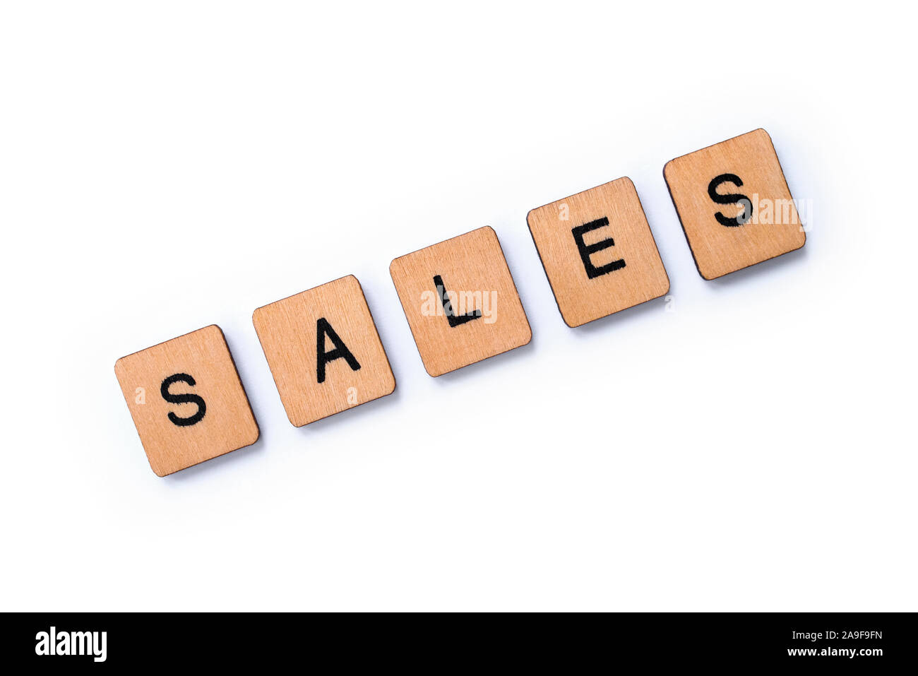 The word SALES, spelt with wooden letter tiles over a white background ...