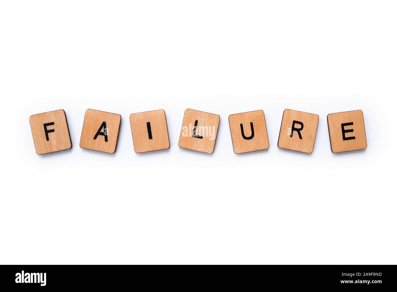The word FAILURE, spelt with wooden letter tiles over a white ...
