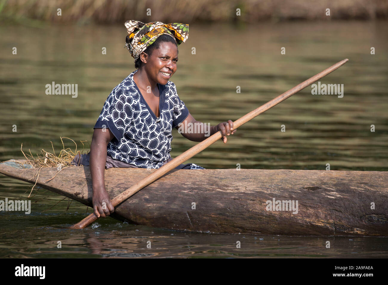 Batwa woman in the dugout, in the Bunyonyi lake, Uganda Stock Photo - Alamy