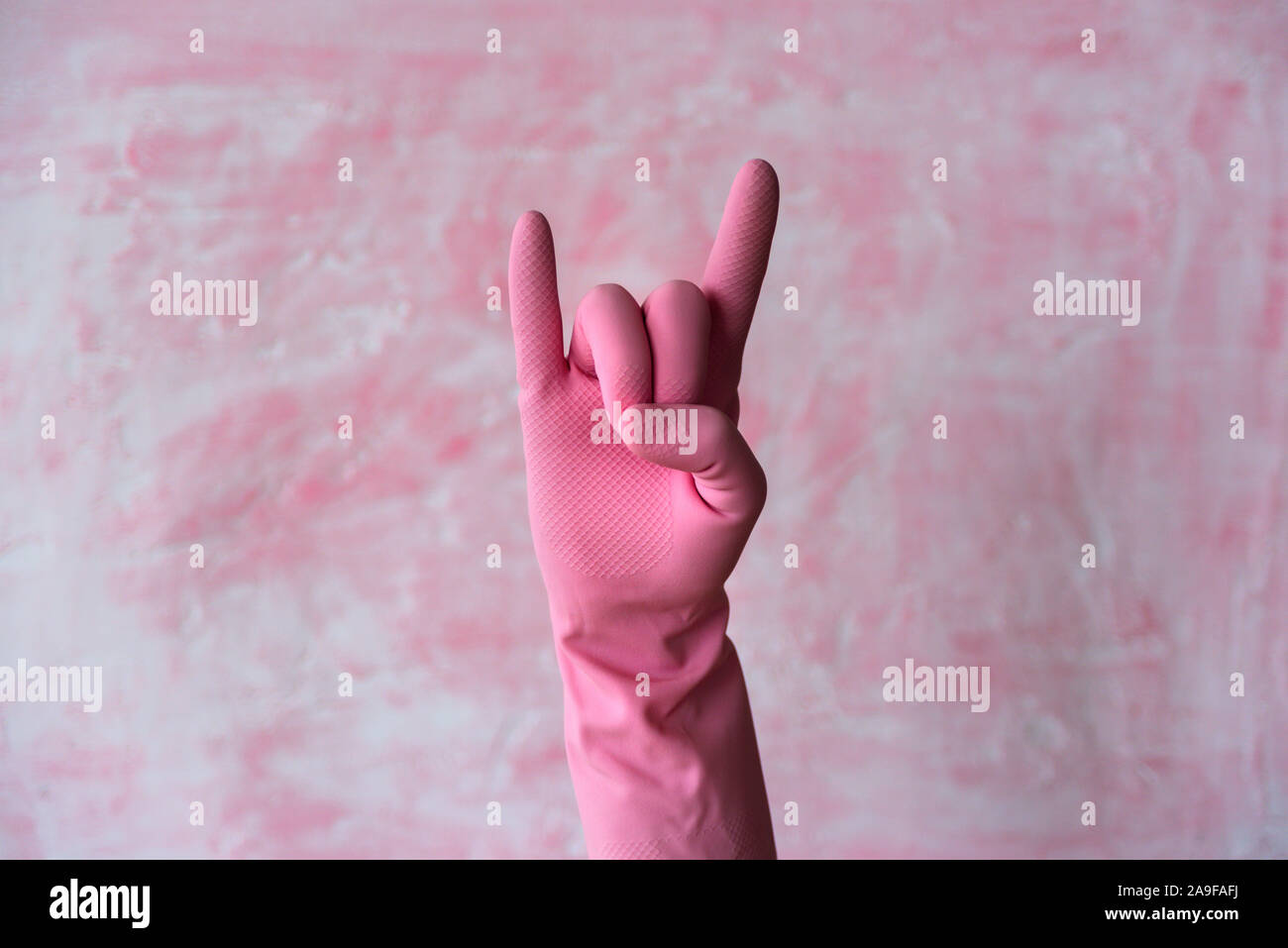 Pink hand rock gesture on pink. Left hander day concept Stock Photo - Alamy