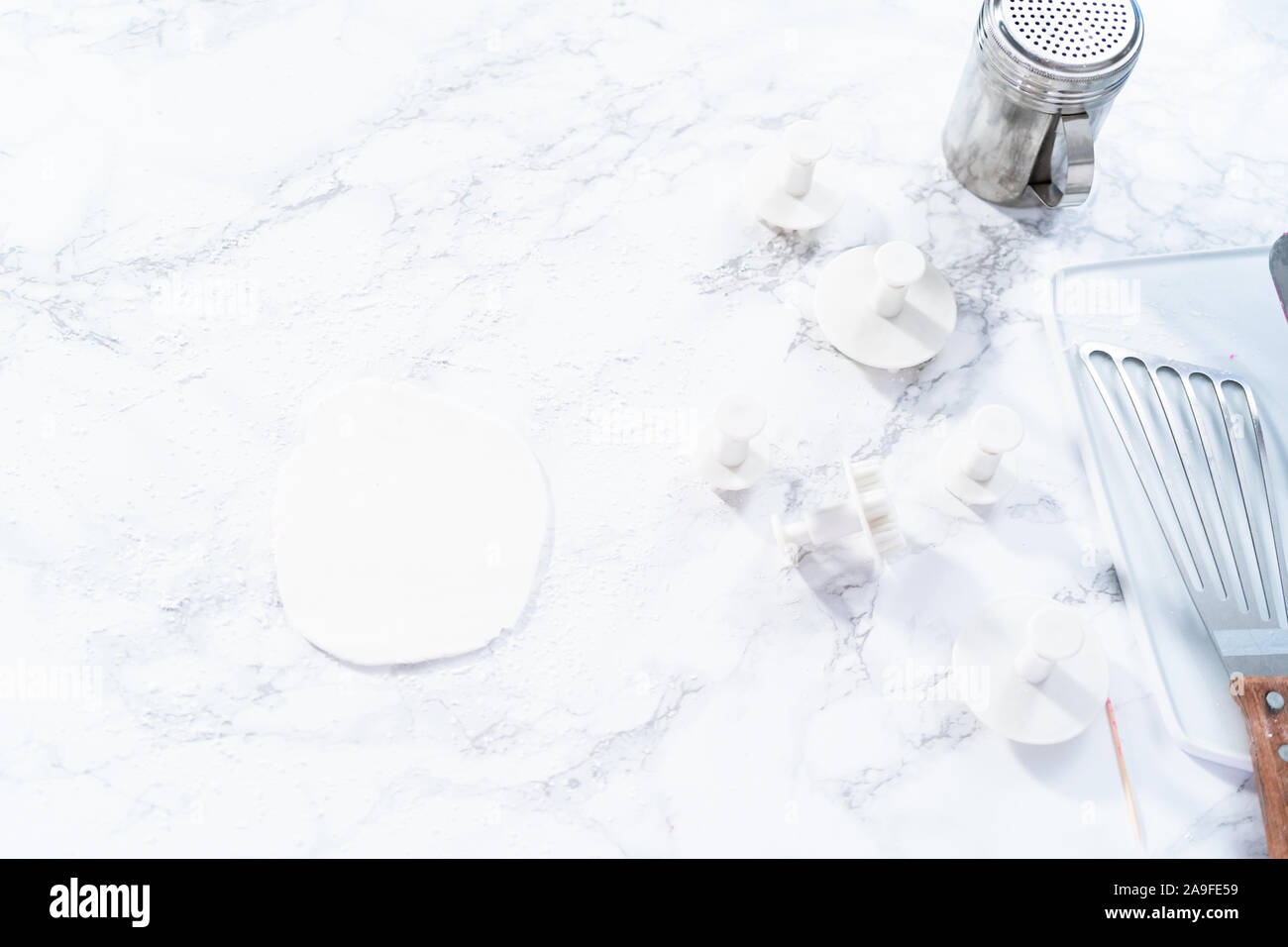 Rolling out fondant to cut snowflake shapes with cookie cutters Stock ...