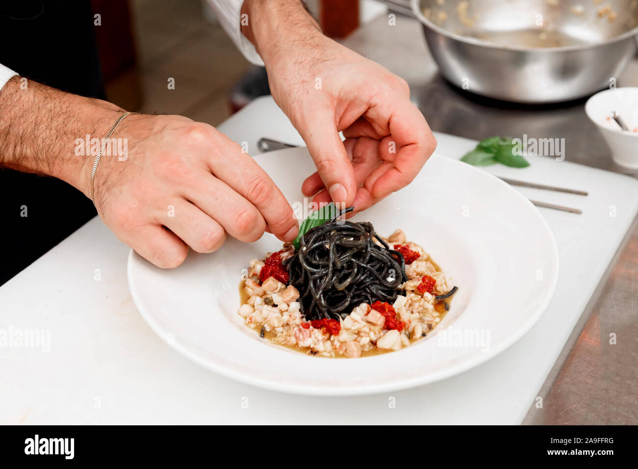 Chef is cooking pasta at commercial kitchen, toned Stock Photo - Alamy