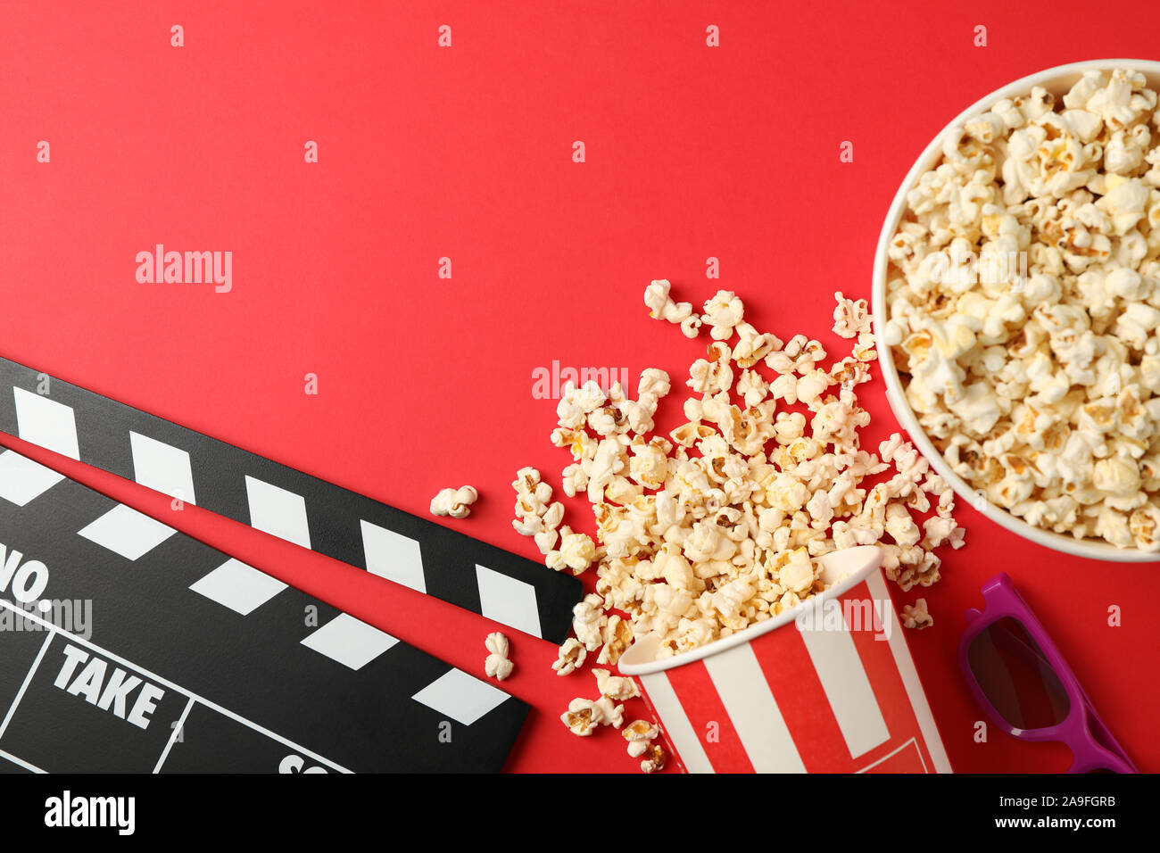 Flat lay. Buckets with popcorn, 3d glasses and clapperboard on red ...